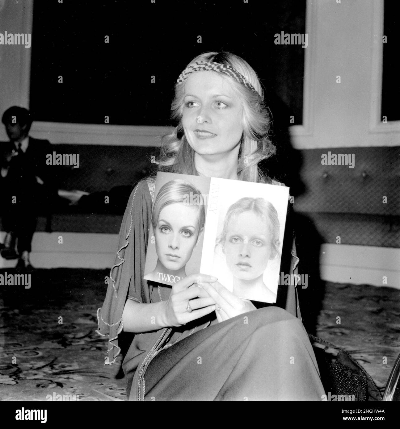 Twiggy, 26, British model, actress and singer, holds a copy of her ...