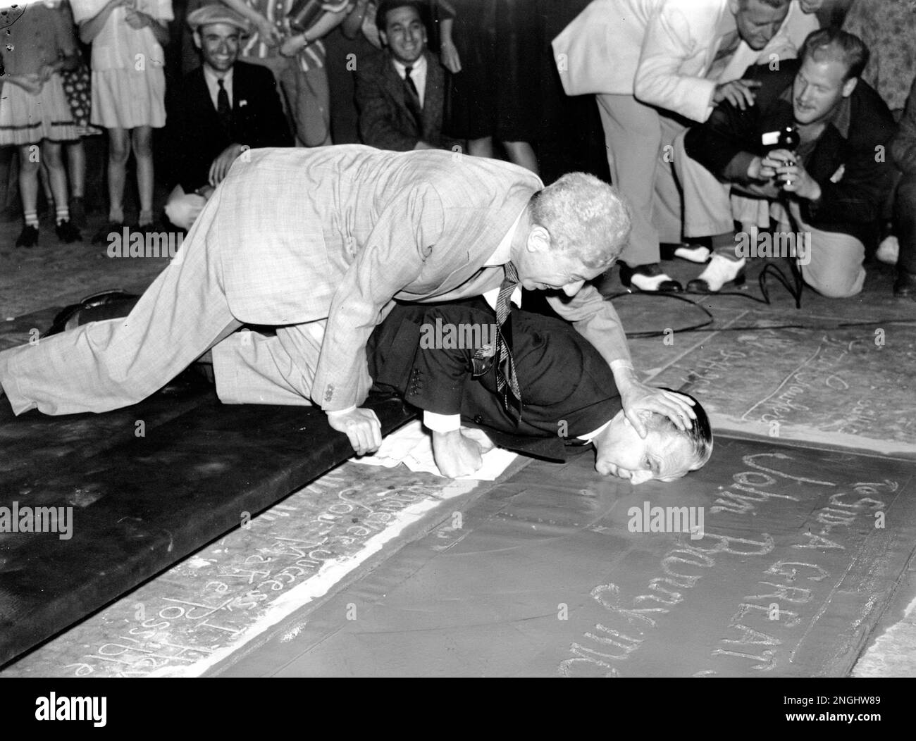 Stage and film actor John Barrymore plants his face into the wet cement ...
