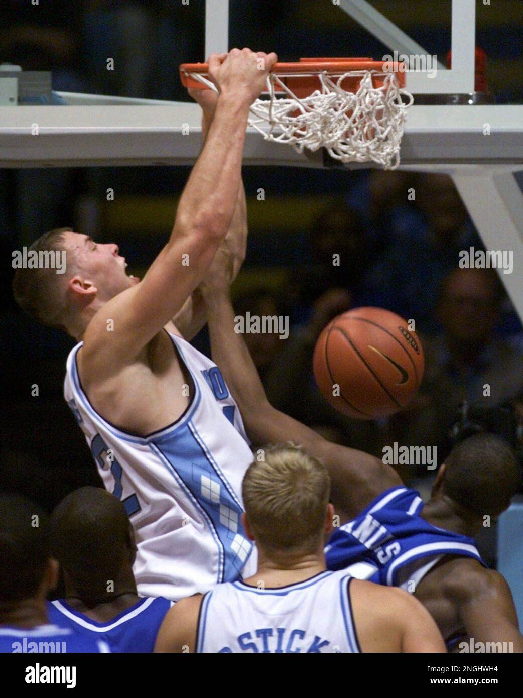 North Carolina's Kris Lang dunks the ball over Kentucky's Erik Daniels ...
