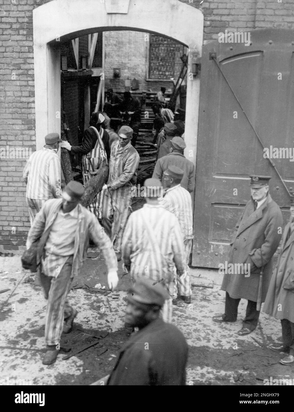Prisoners work to clear away debris after a fire at the Ohio State ...