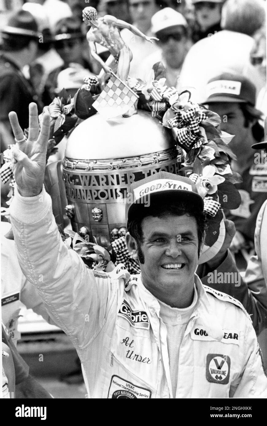 Formula 1 race car driver Al Unser waves three fingers in Victory Lane ...