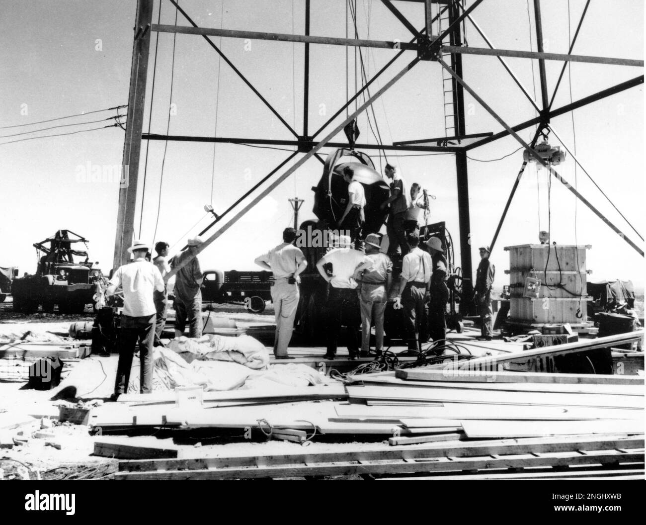 Scientists and workmen rig the world's first atomic bomb to raise it up ...