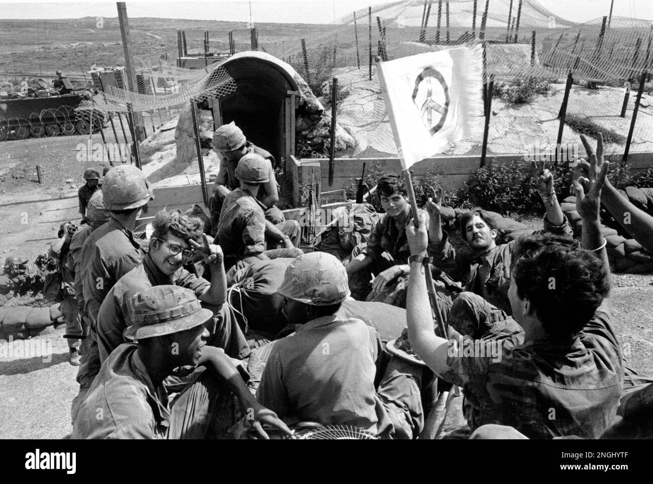 U.S. soldiers raise a peace flag and give the "V" sign as they wait to ...