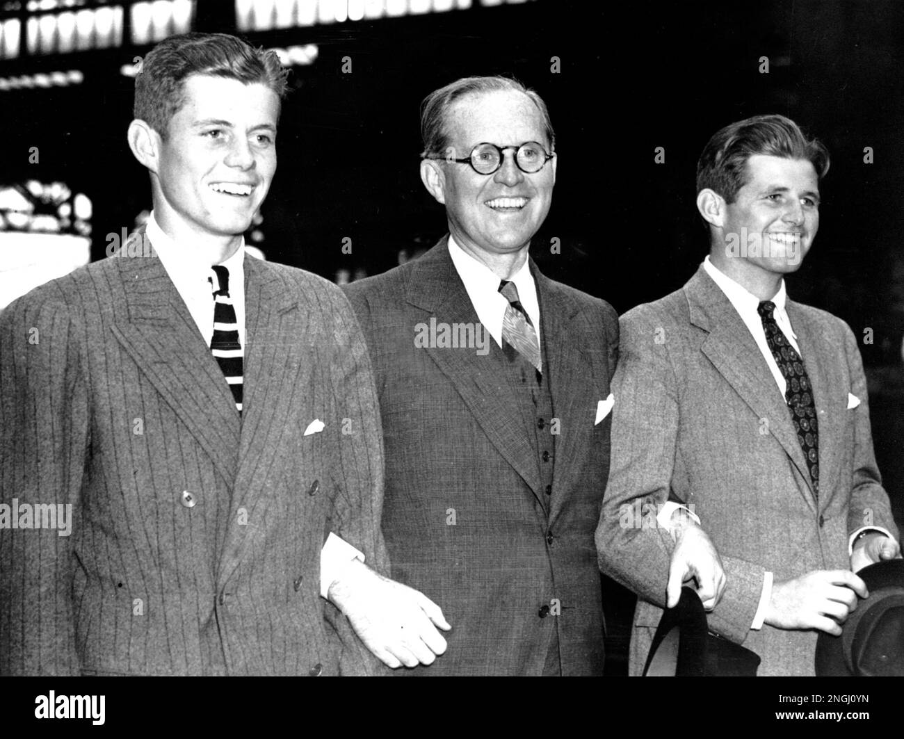 Joseph P. Kennedy, center, links arms with his sons, John F. Kennedy ...
