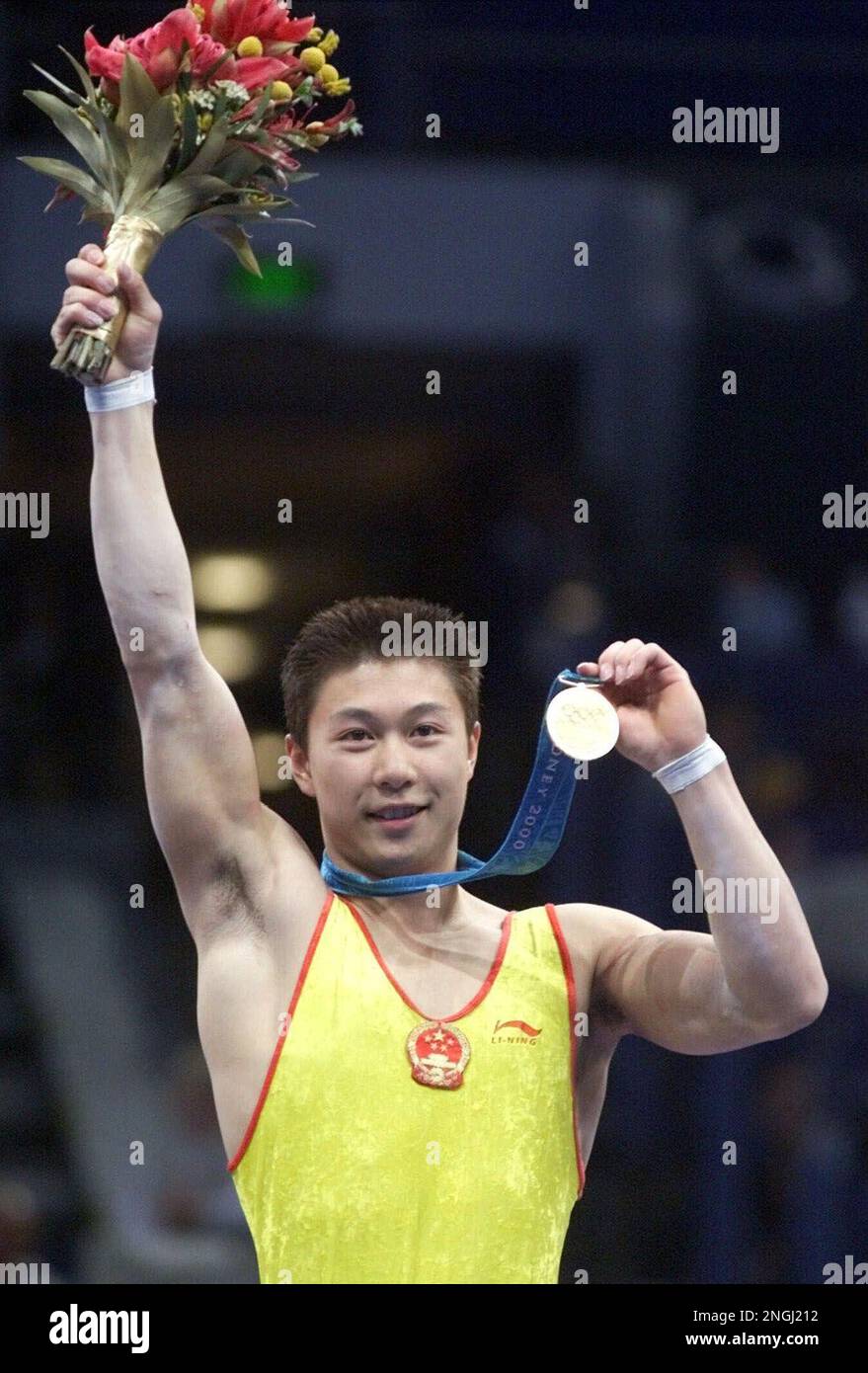 Li Xiaopeng of China holds up his gold medal for the parallel bars ...