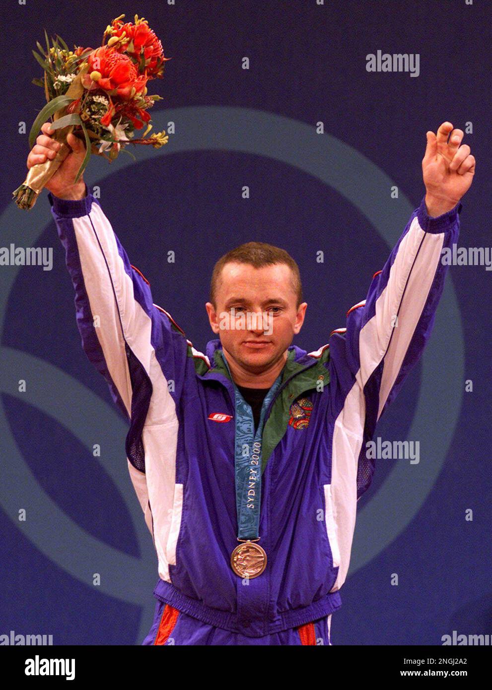 Belarus's Sergei Lavrenov raises his arms after being awarded the bronze medal in the men's 69 ...