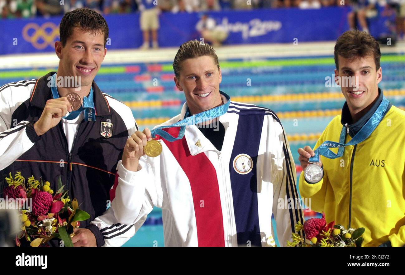 U.S. gold medal winning swimmer Lenny Krayzelburg, center, stands with ...