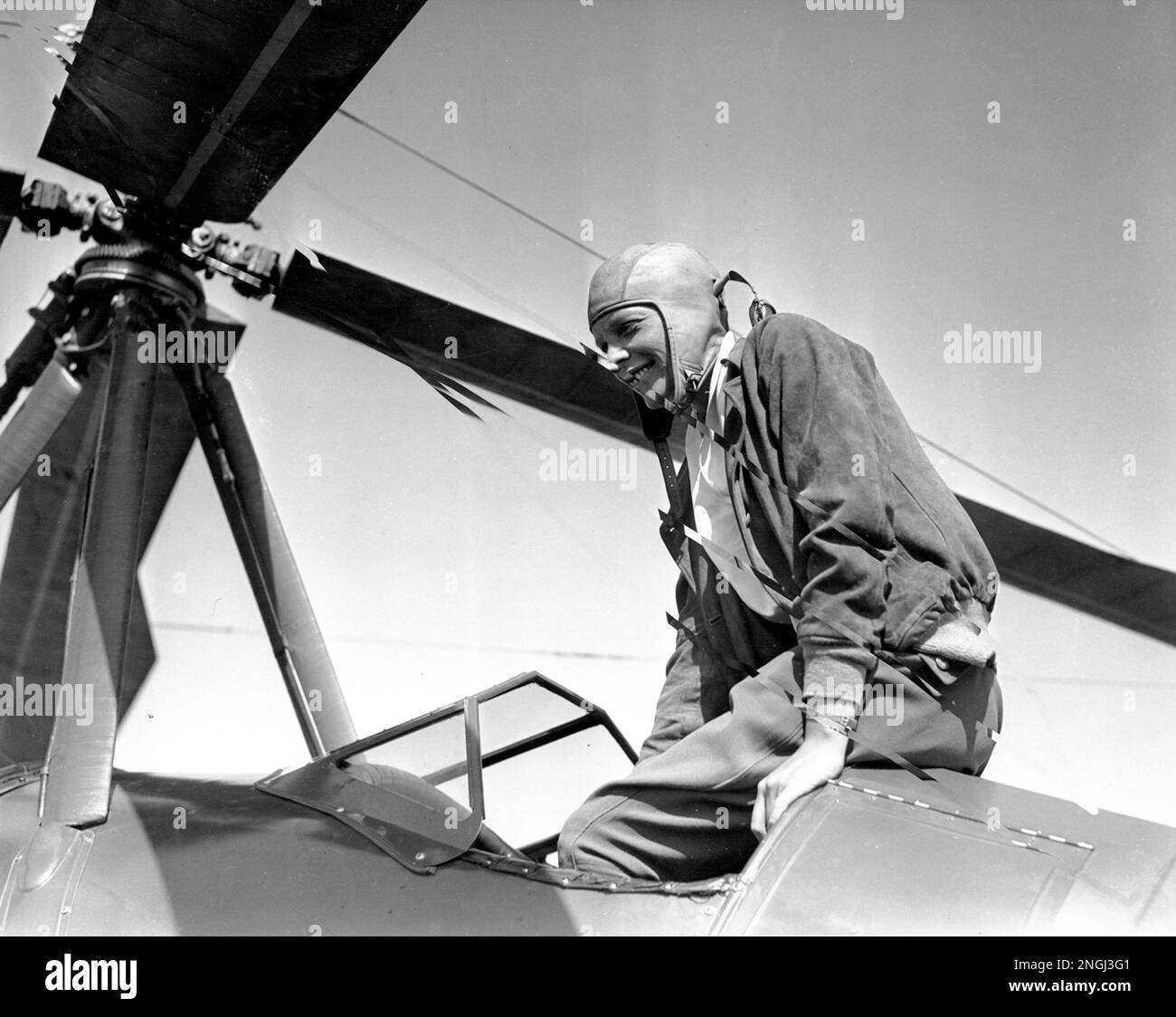 Aviator Amelia Earhart lifts herself from the cockpit of her airplane ...