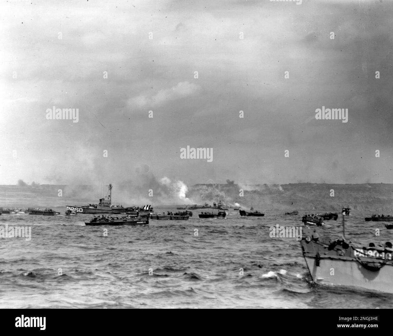 Landing barges rest in the waters off the beaches of Iwo Jima during ...