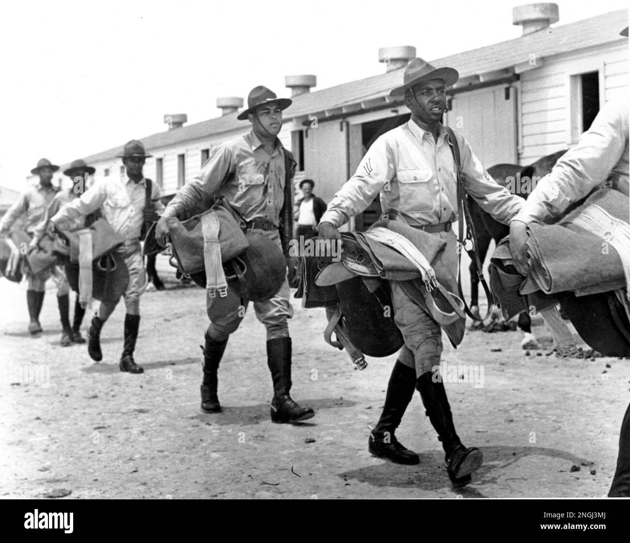 Joe Louis, second from left, walks from the stables with fellow ...