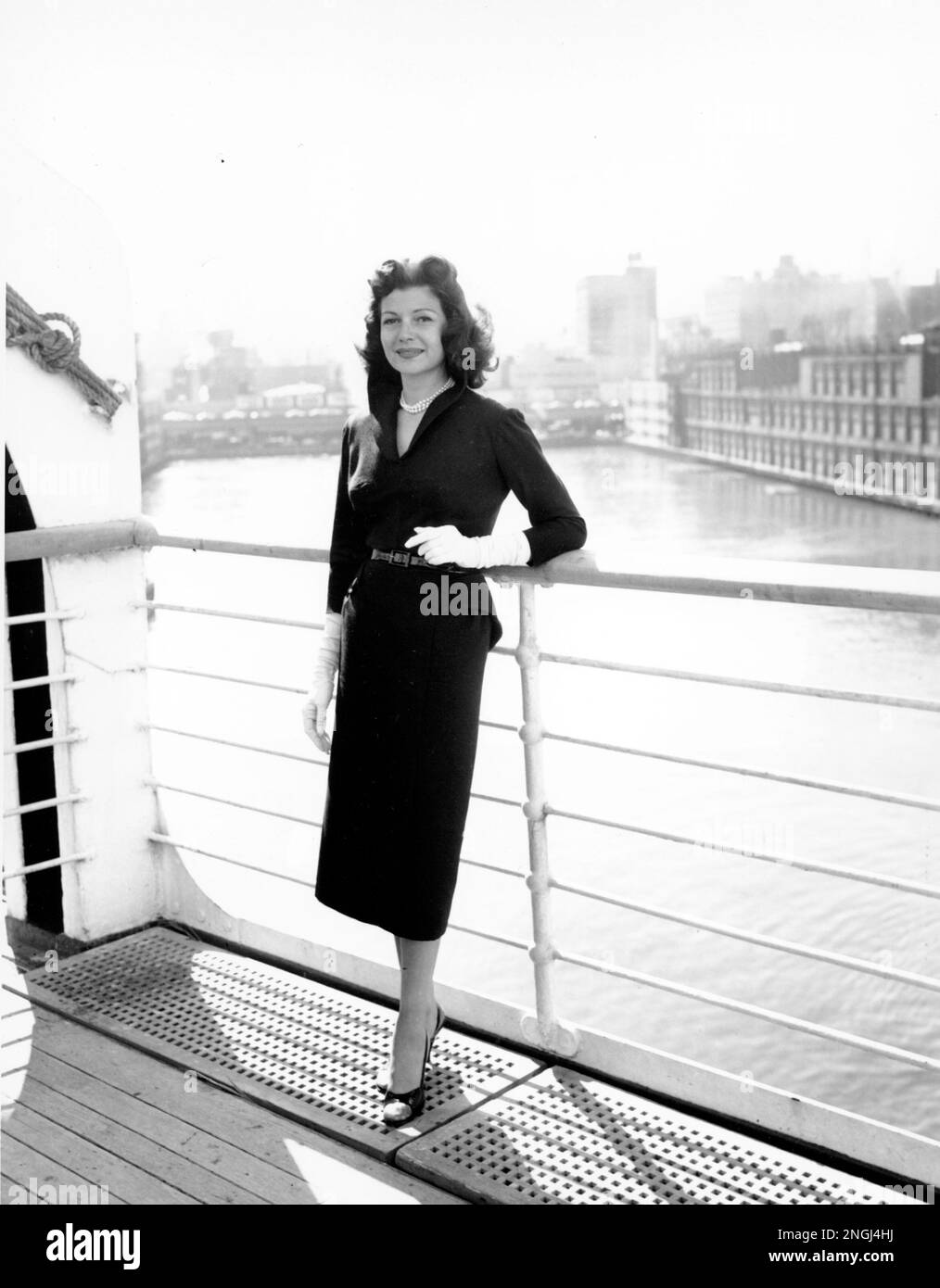 Actress Rita Hayworth is posing for a photographer on the "Queen ...
