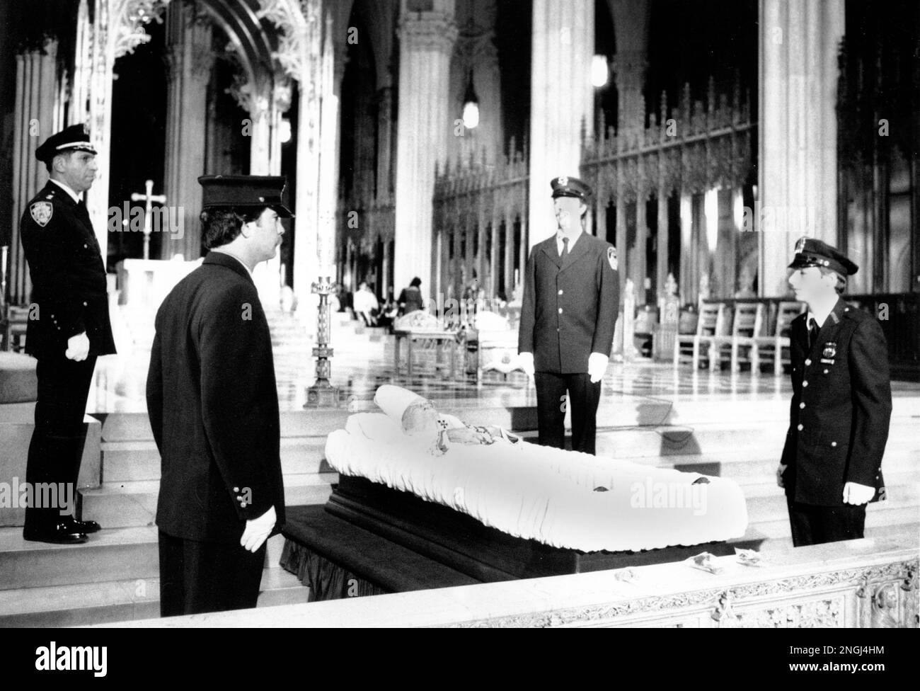 An honor guard of police and firemen stand beside the remains of ...