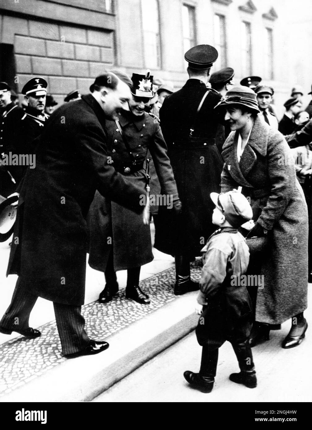 German chancellor Adolf Hitler greets a young boy on a street in Berlin ...