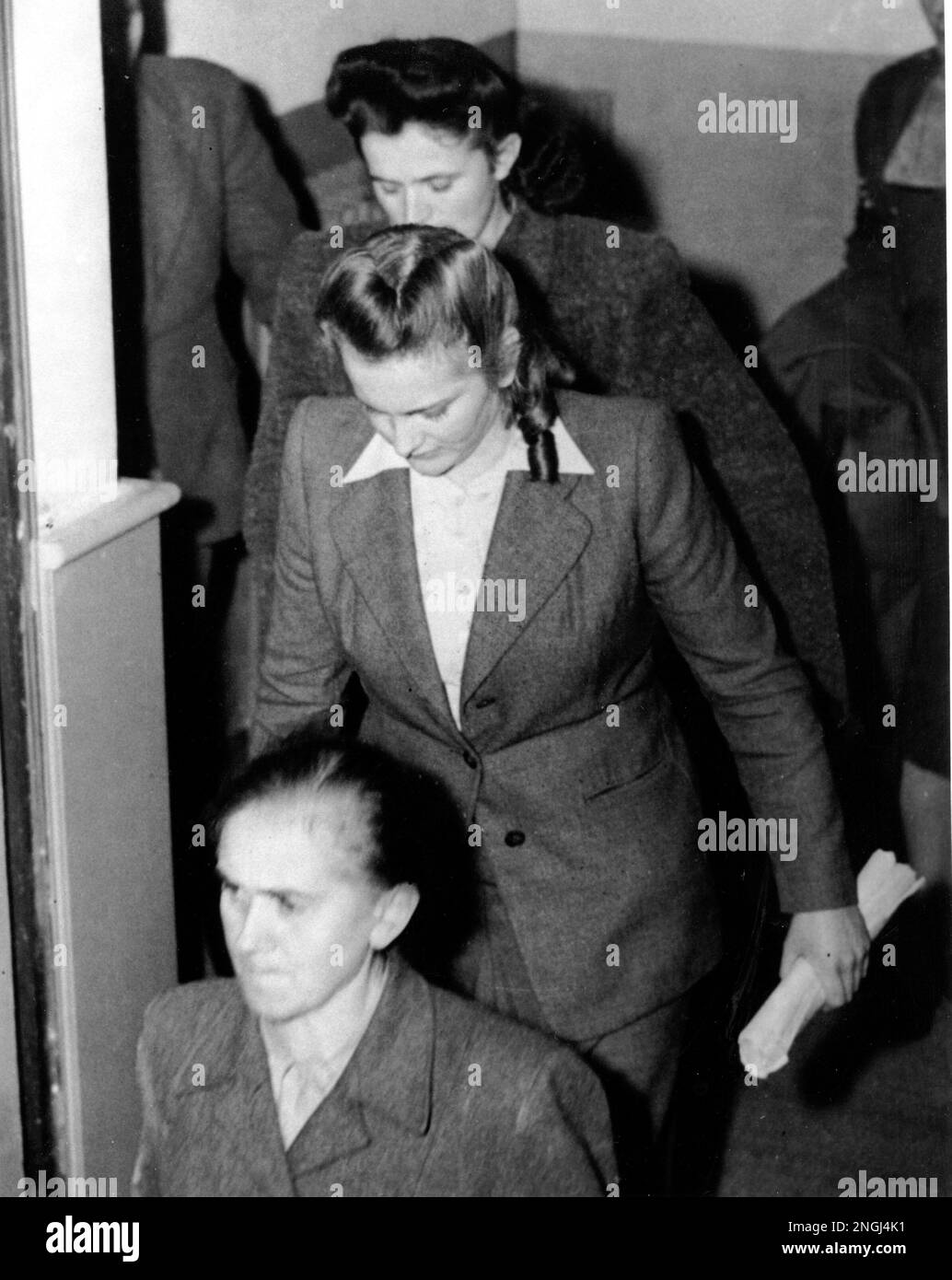 Irma Grese, center with her head bowed, leaves the courtroom in ...