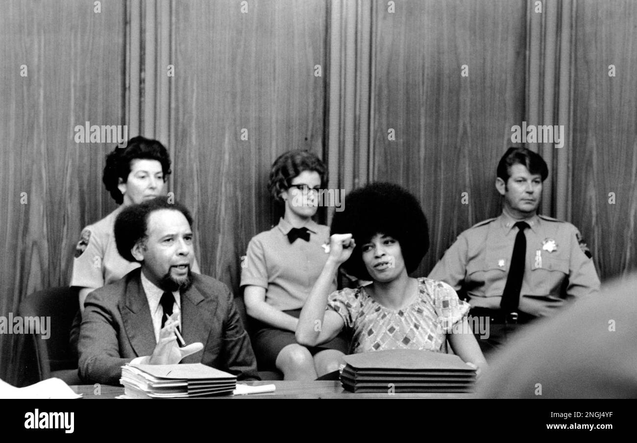 Angela Davis raises her fist to give her power salute as she sits in ...