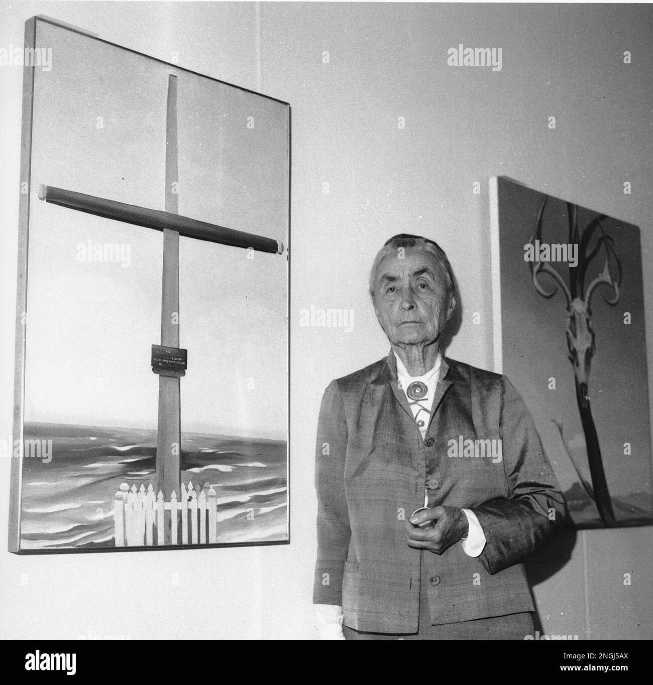 Georgia O'Keeffe stands next to her original oil paintings during a ...
