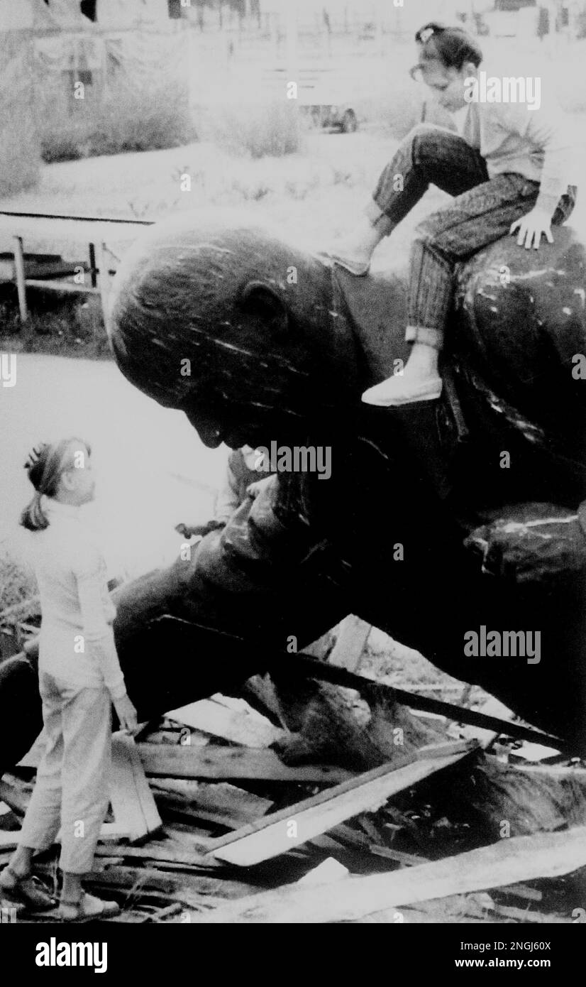 This photo shows children playing on the fallen statue of Vladimir ...