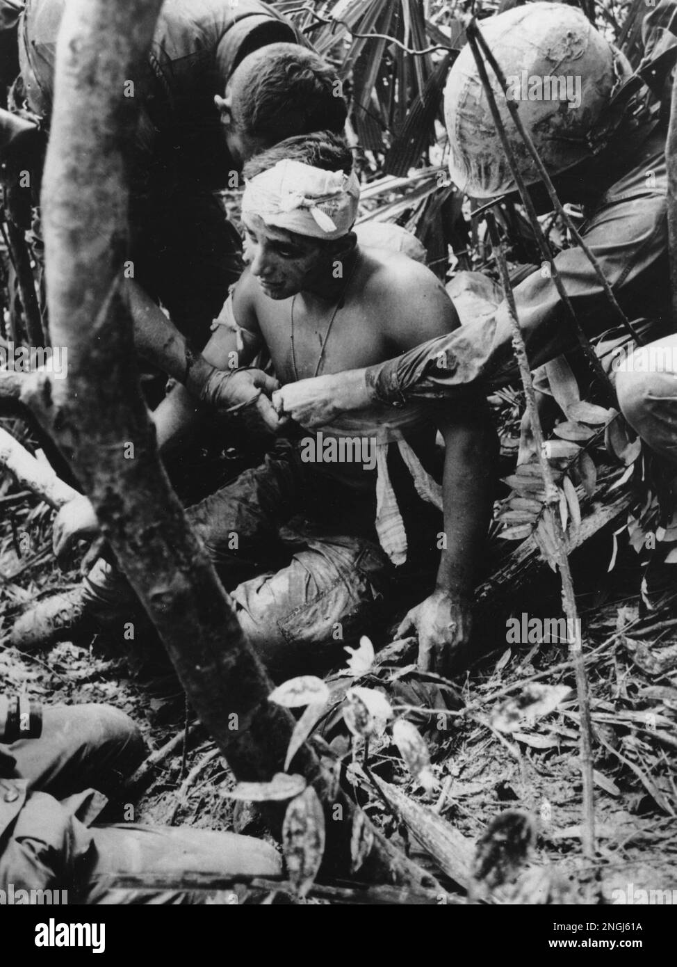 Shown in this photo are comrades binding the wounds of a soldier of the ...