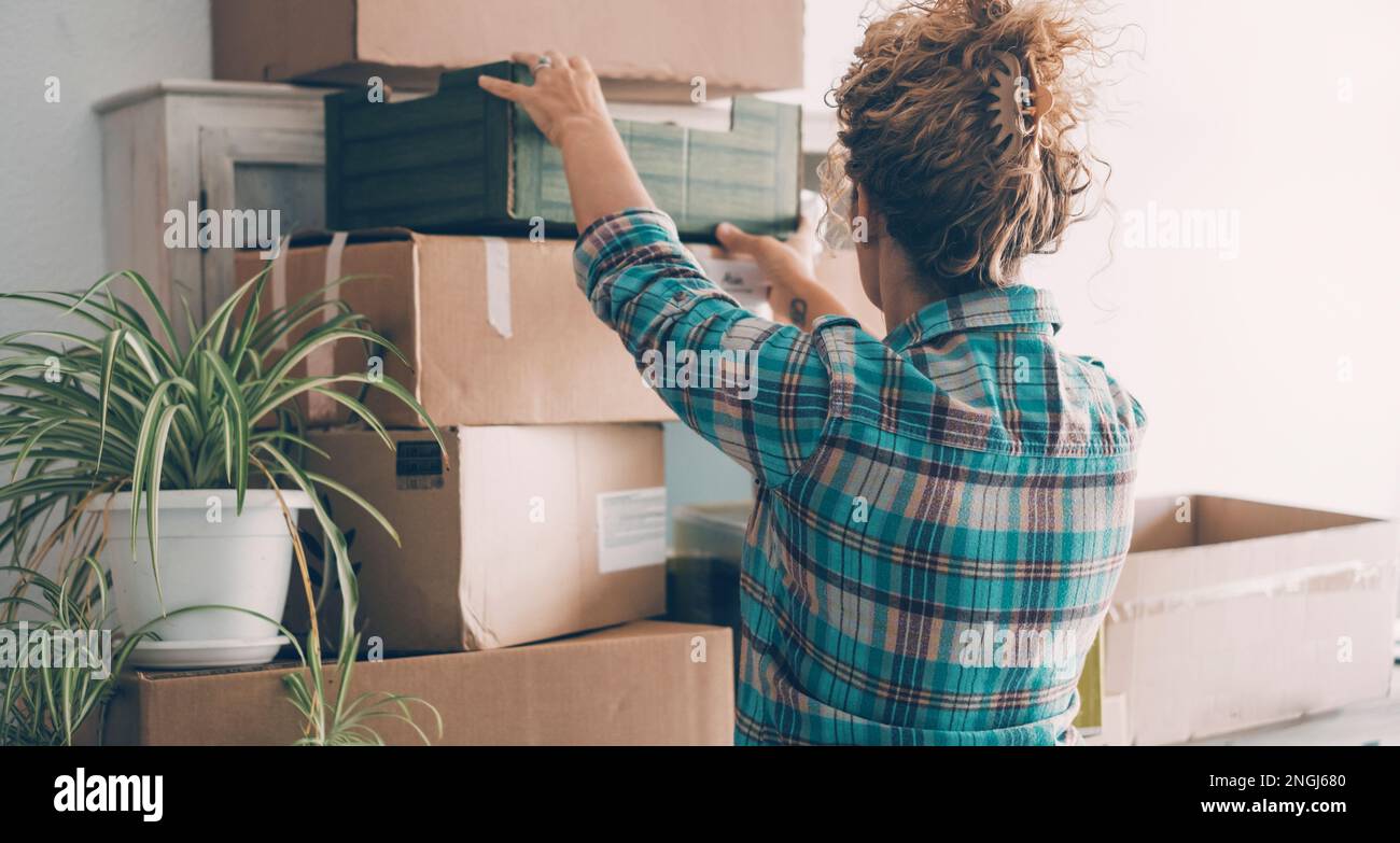 One lady moving house and working with cardboard carton box against a ...
