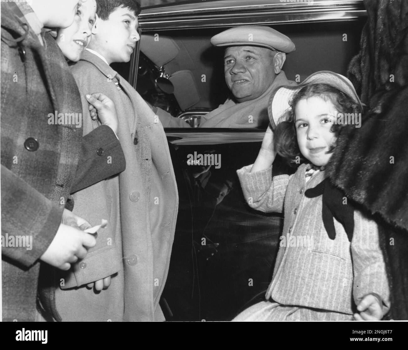 Babe Ruth sits in his new car chatting with a group of youngsters in ...