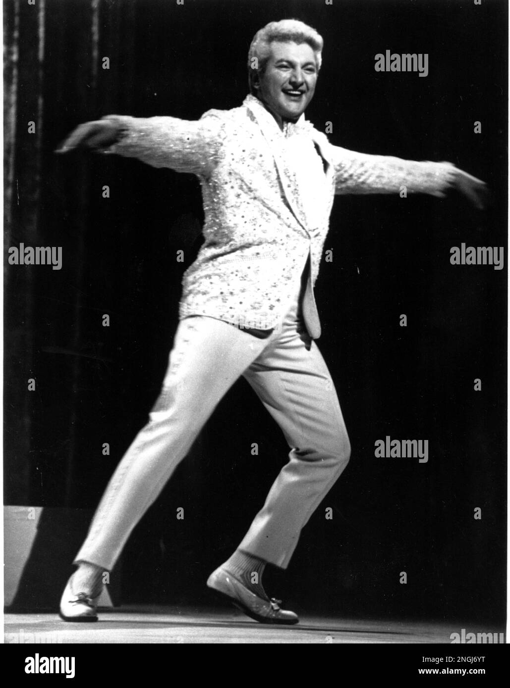 Liberace, pianist and television entertainer, leaves his piano to dance ...