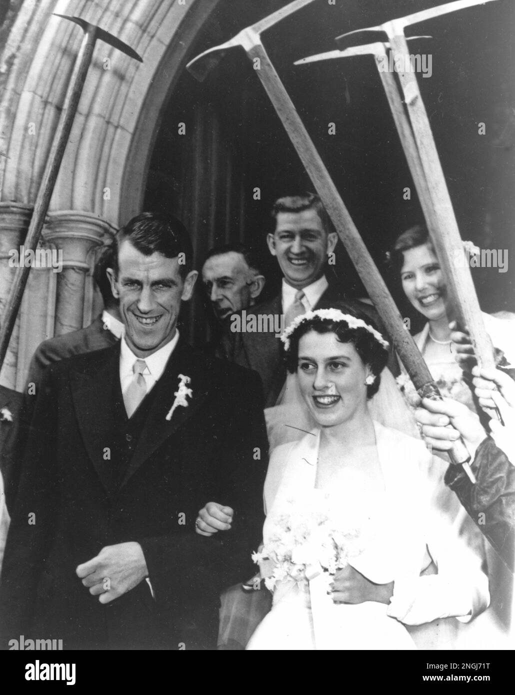 Sir Edmund Hillary and his bride Louise Rose, walk through an arch of ...