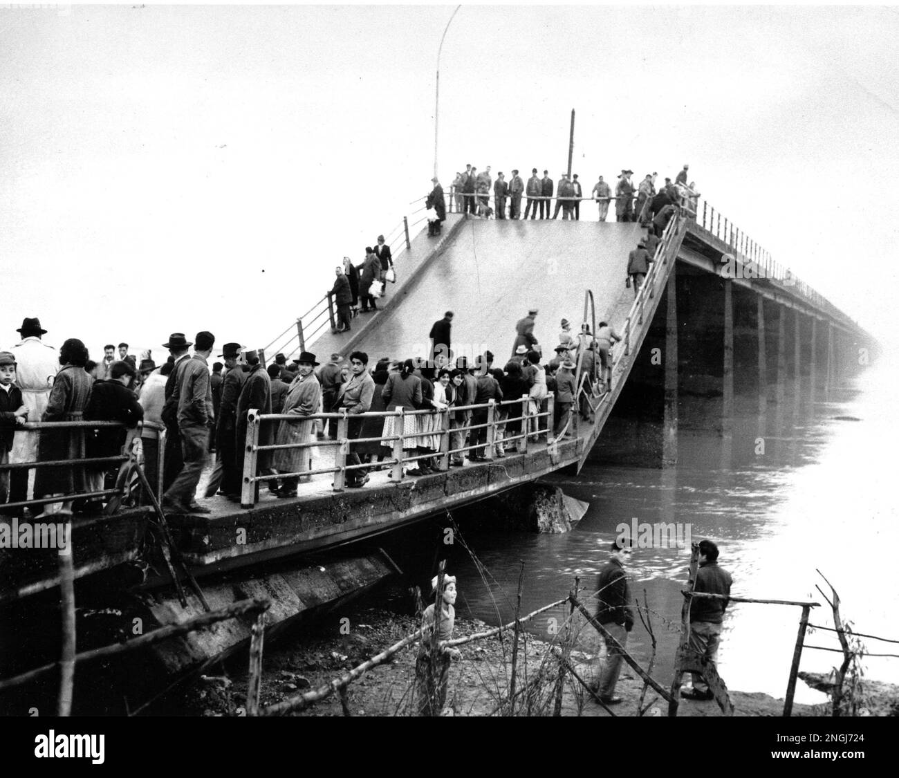 Survivors stand on part of a collapsed bridge across Chile's largest ...