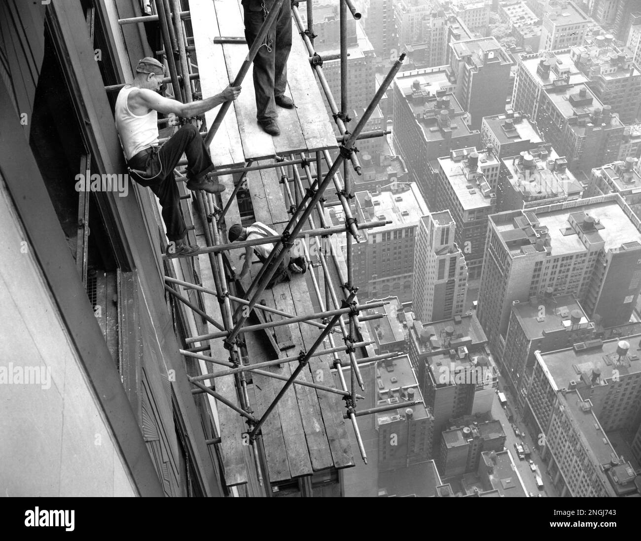 Workmen rig scaffolding on the south side of the 78th floor of the ...