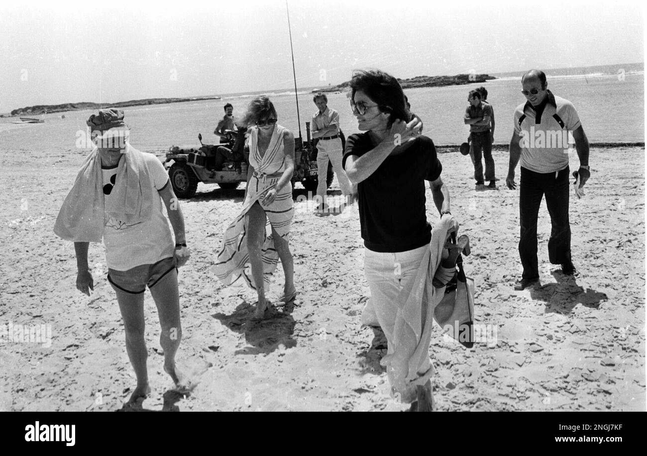 Mrs. Jacqueline Kennedy Onassis carries her sandals May 15, 1978 during ...
