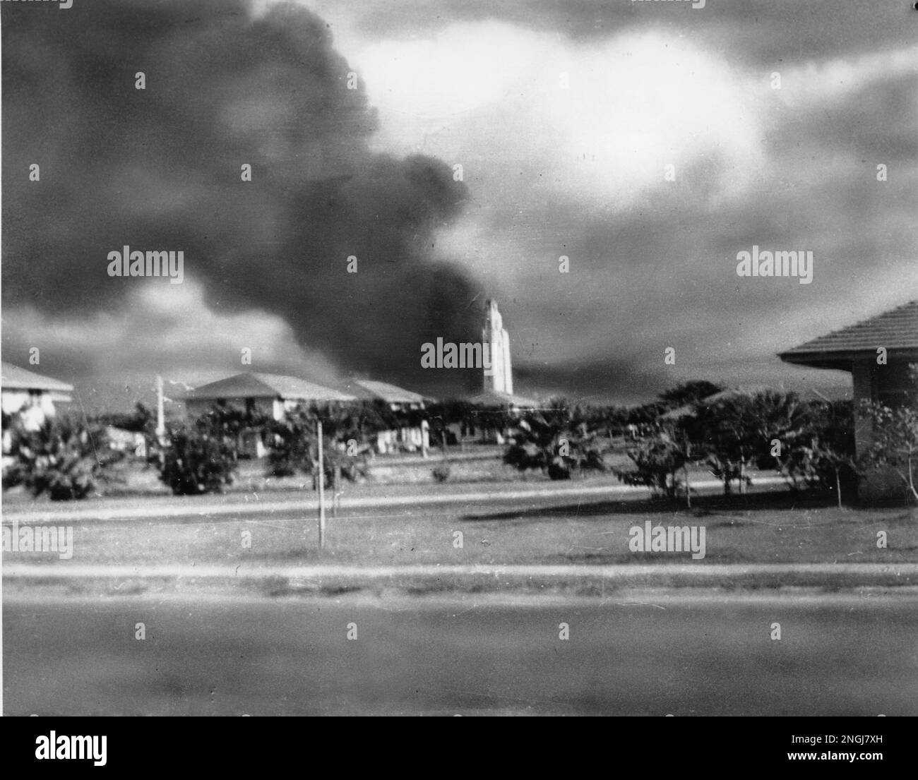 A column of black smoke rises from the U.S. Navy base in Pearl Harbor ...