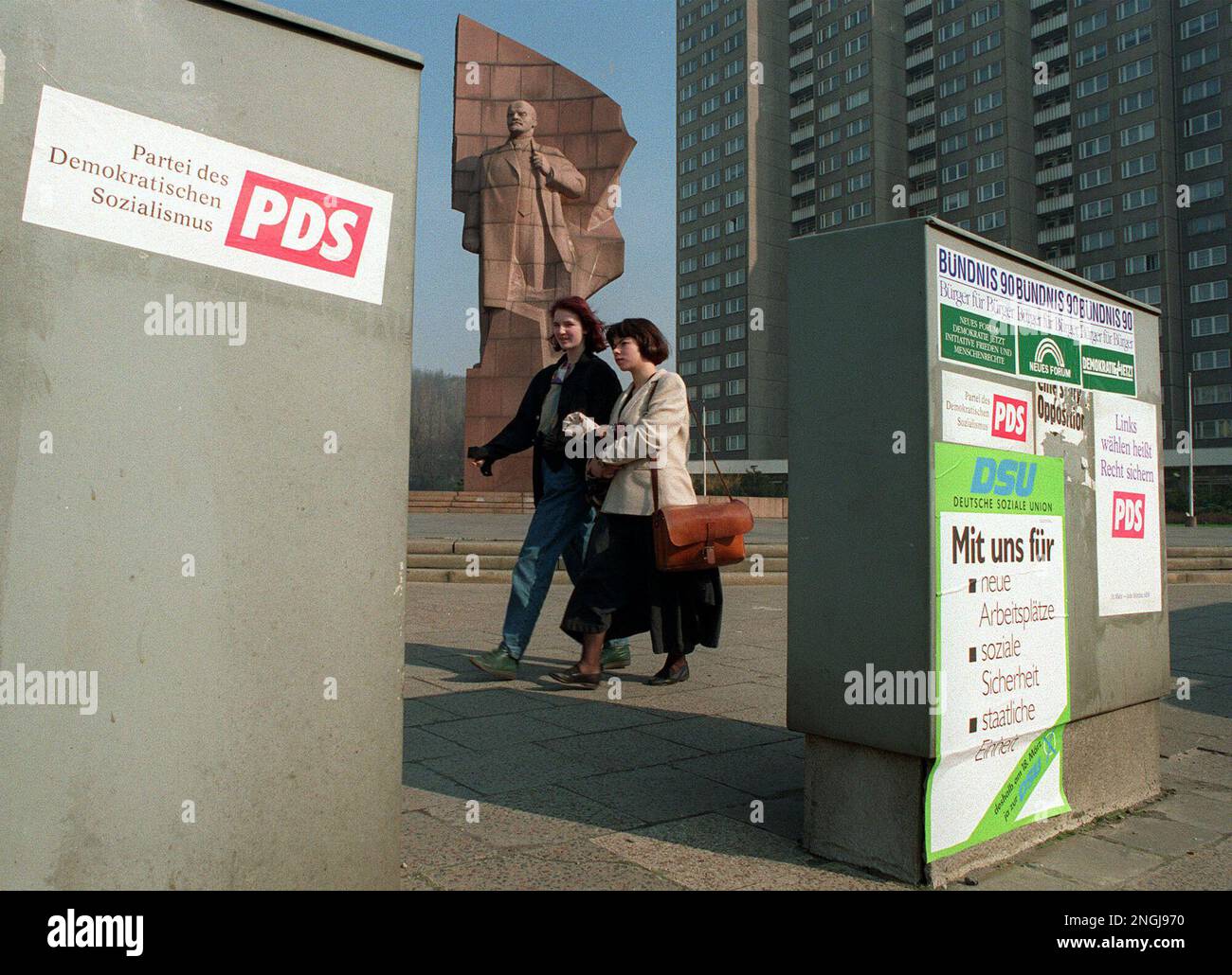 Two pedestrians pass the Lenin monument (center) which is framed by ...