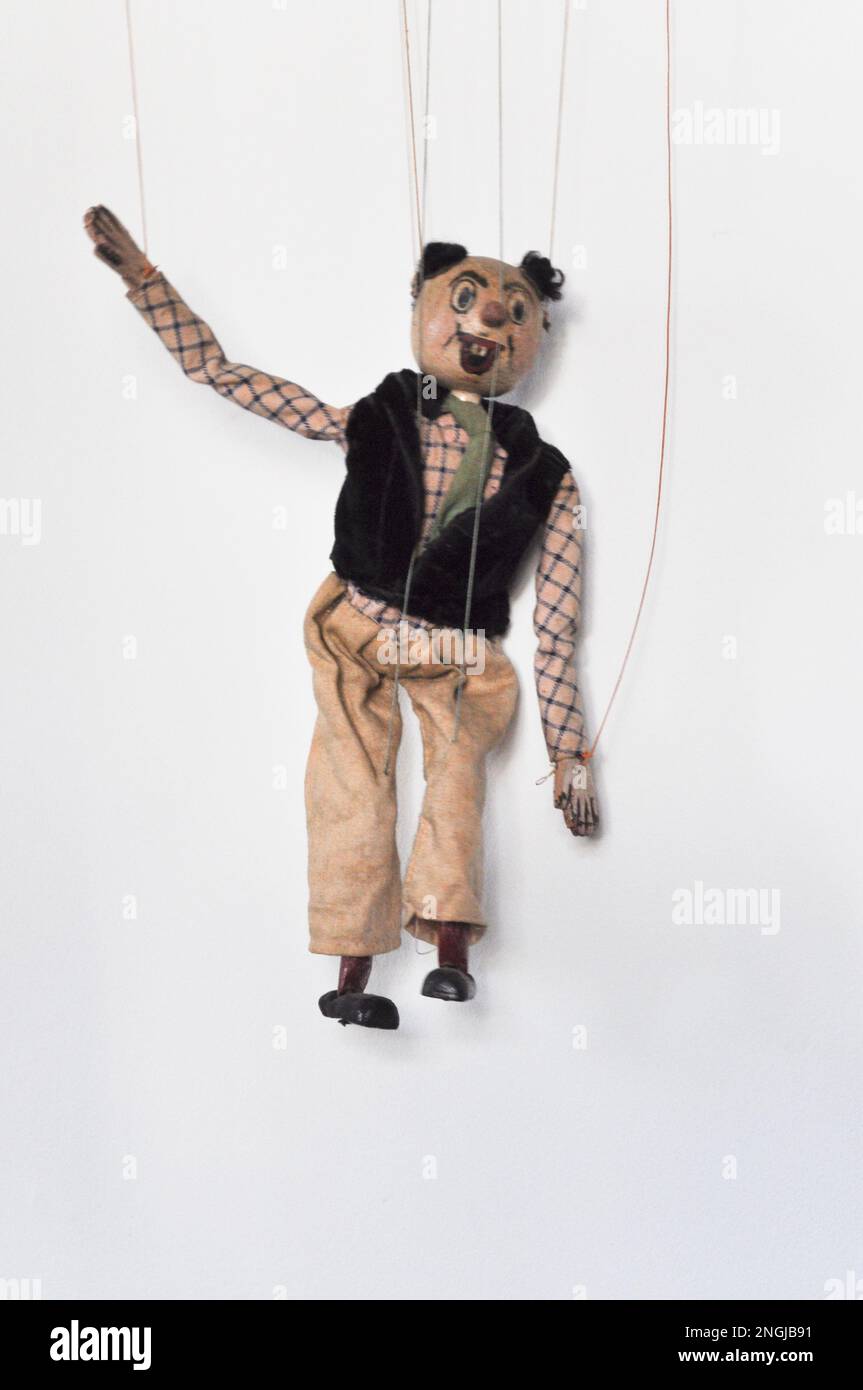 A handmade vintage marionette puppet on a string of a clown like figure ...
