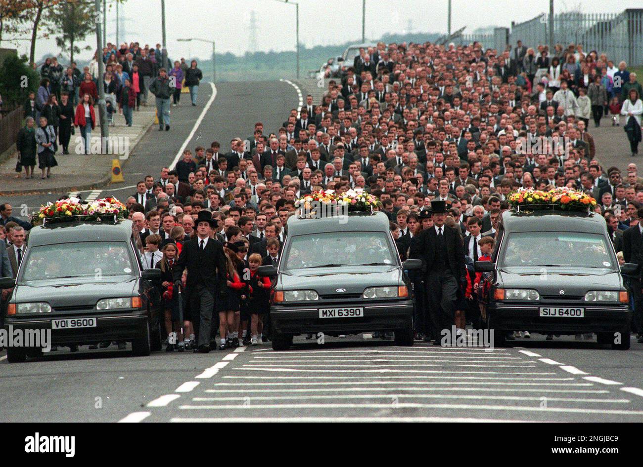 Hundreds of mourners follow three hearses, containing the coffins of 7 ...