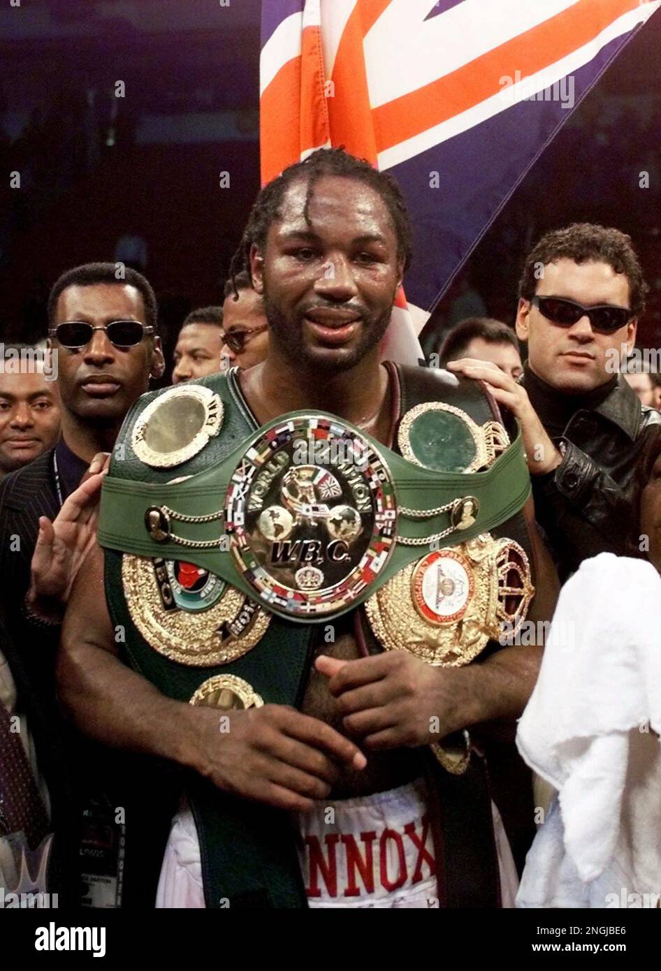 Lennox Lewis, of Britain, holds all three of his championship belts ...