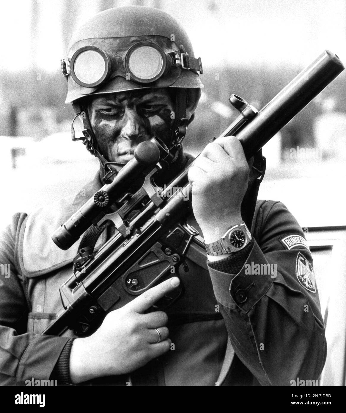 A member of West Germanys famed GSG 9 anti-terrorist squad craddles his ...