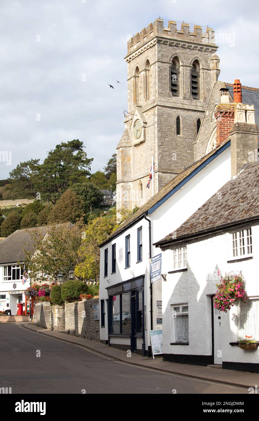 The church and whitewashed shops on the high street in the picturesque ...