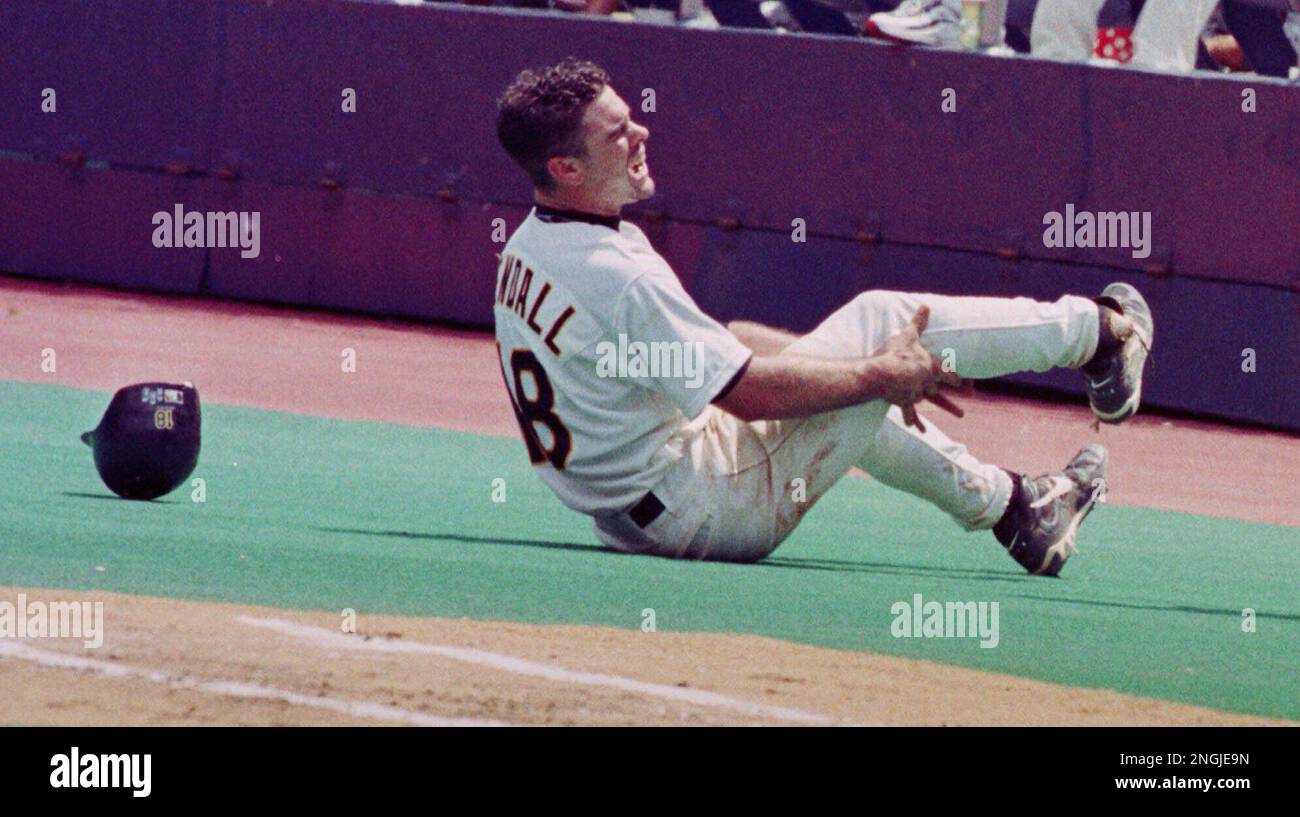 Pittsburgh Pirates' Jason Kendall holds his leg after breaking his ...