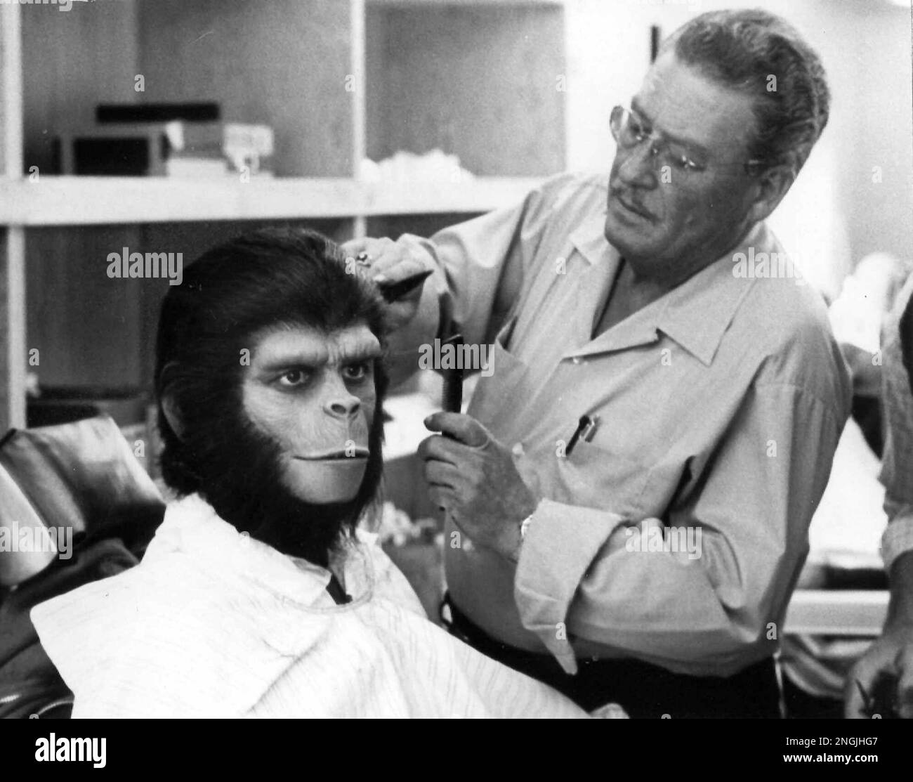 Actor Roddy McDowall gets his wig adjusted by an unidentified makeup ...