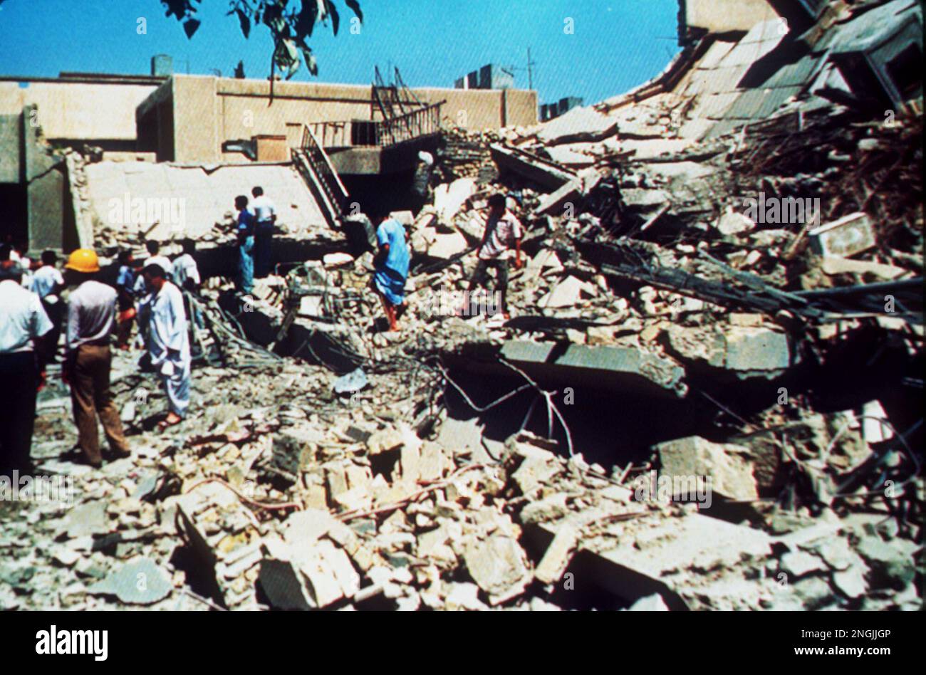 Survivors and rescue workers walk amidst the rubble left by a U.S ...