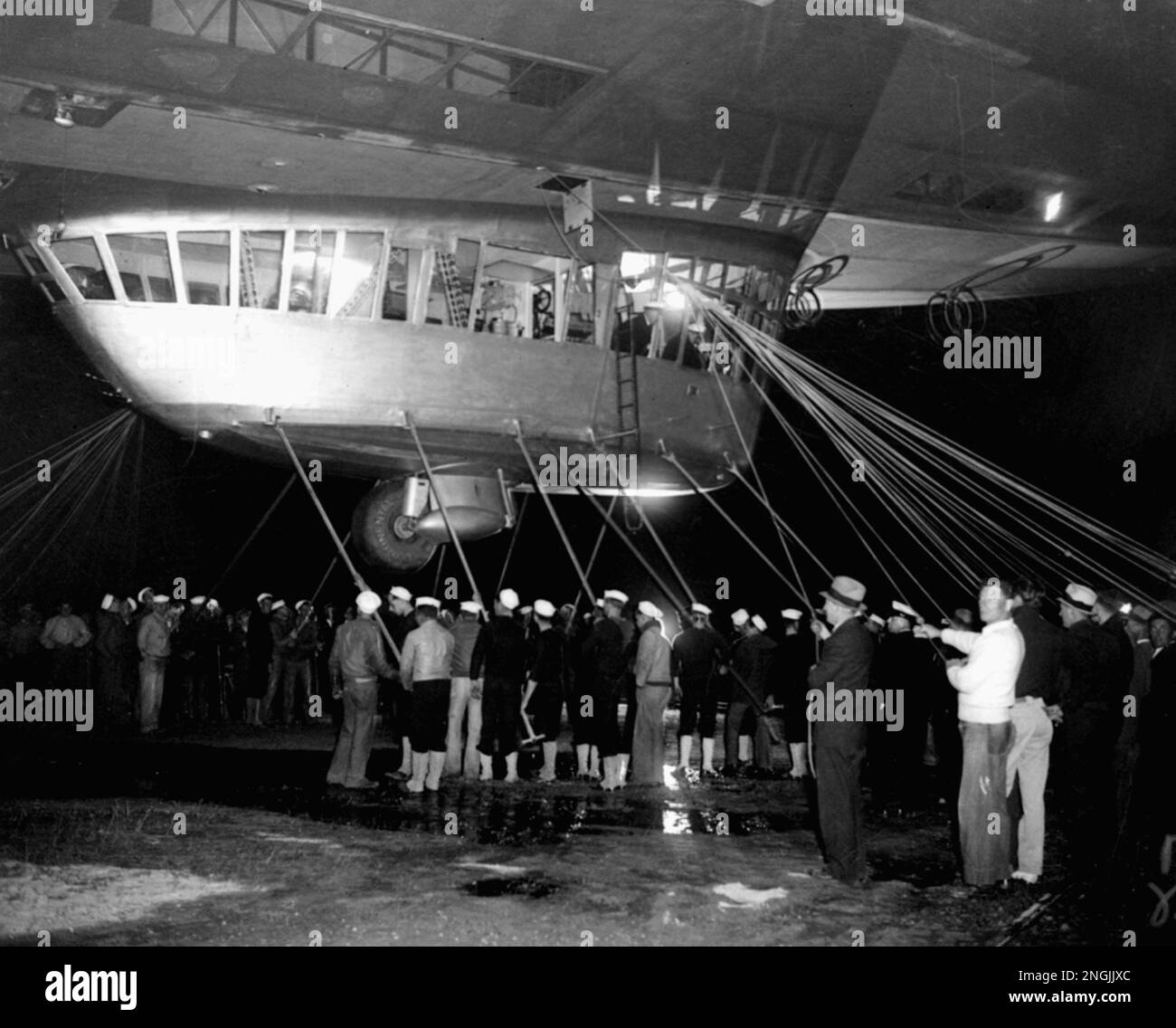Spectators and ground crew surround the gondola of the German zeppelin ...