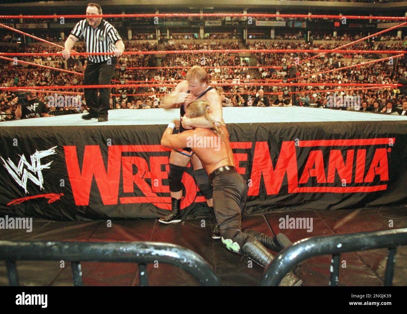 Wrestler Owen Hart, left, and Triple H, right, battle outside the ring ...