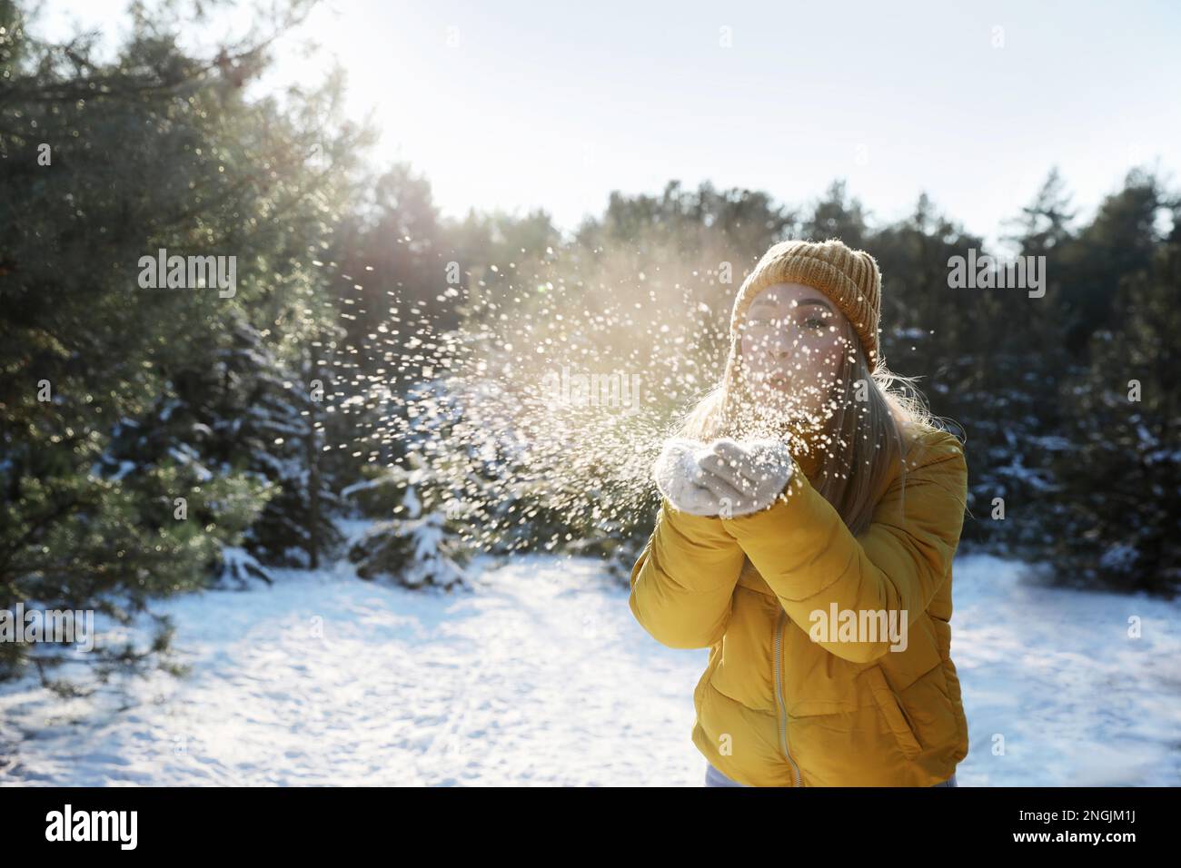 Woman blowing snow from hands in winter forest, space for text Stock Photo - Alamy