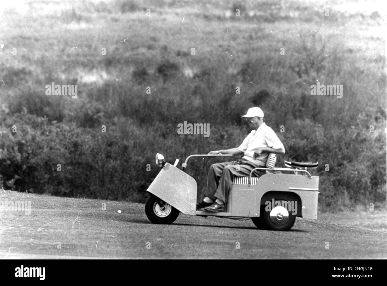 President Eisenhower is shown riding in an electric golf cart at the ...
