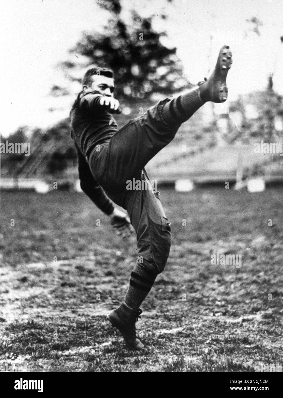 Dwight Eisenhower is shown kicking a football during a practice session ...
