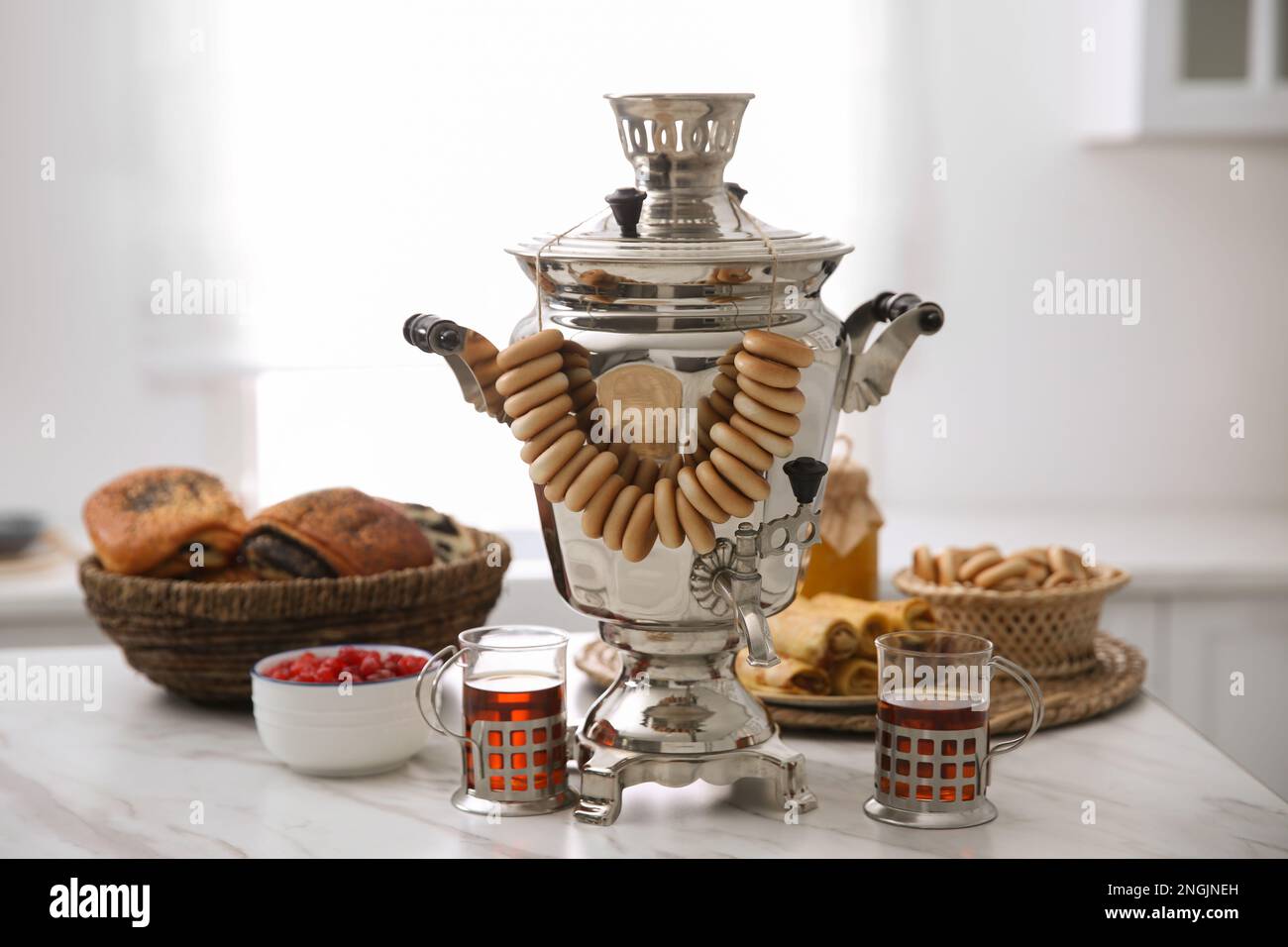 Traditional Russian samovar with treats on white table in kitchen Stock ...