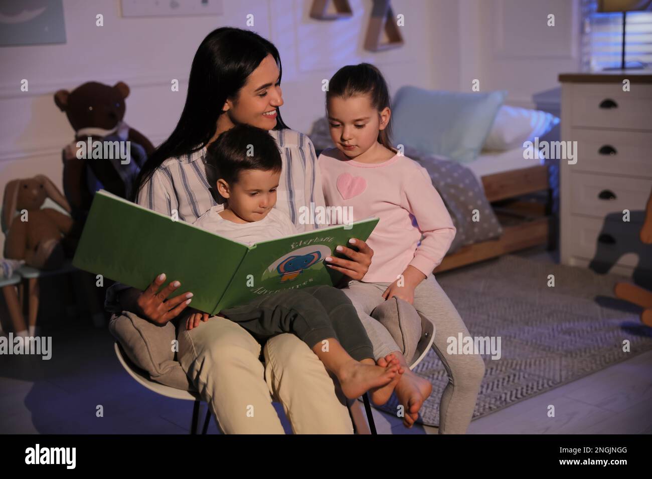 Mother reading bedtime story to her children at home Stock Photo - Alamy