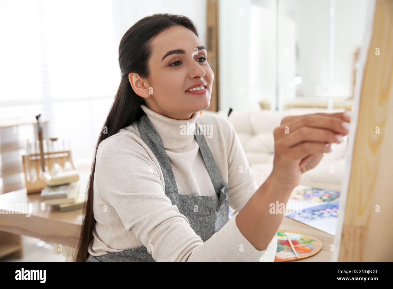Young woman drawing on canvas in studio Stock Photo - Alamy
