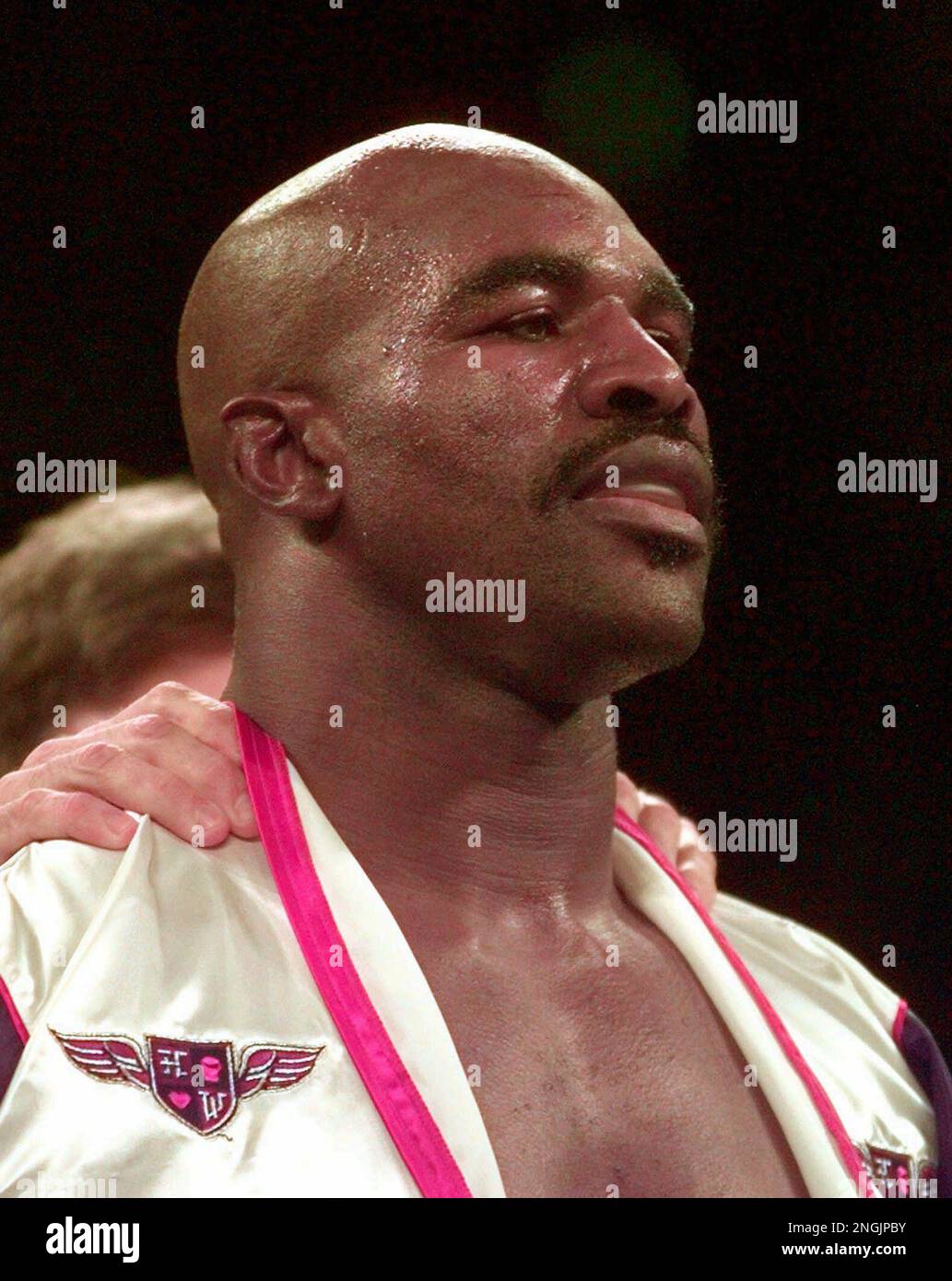 With a chunk of his ear missing, Evander Holyfield stands in the ring ...