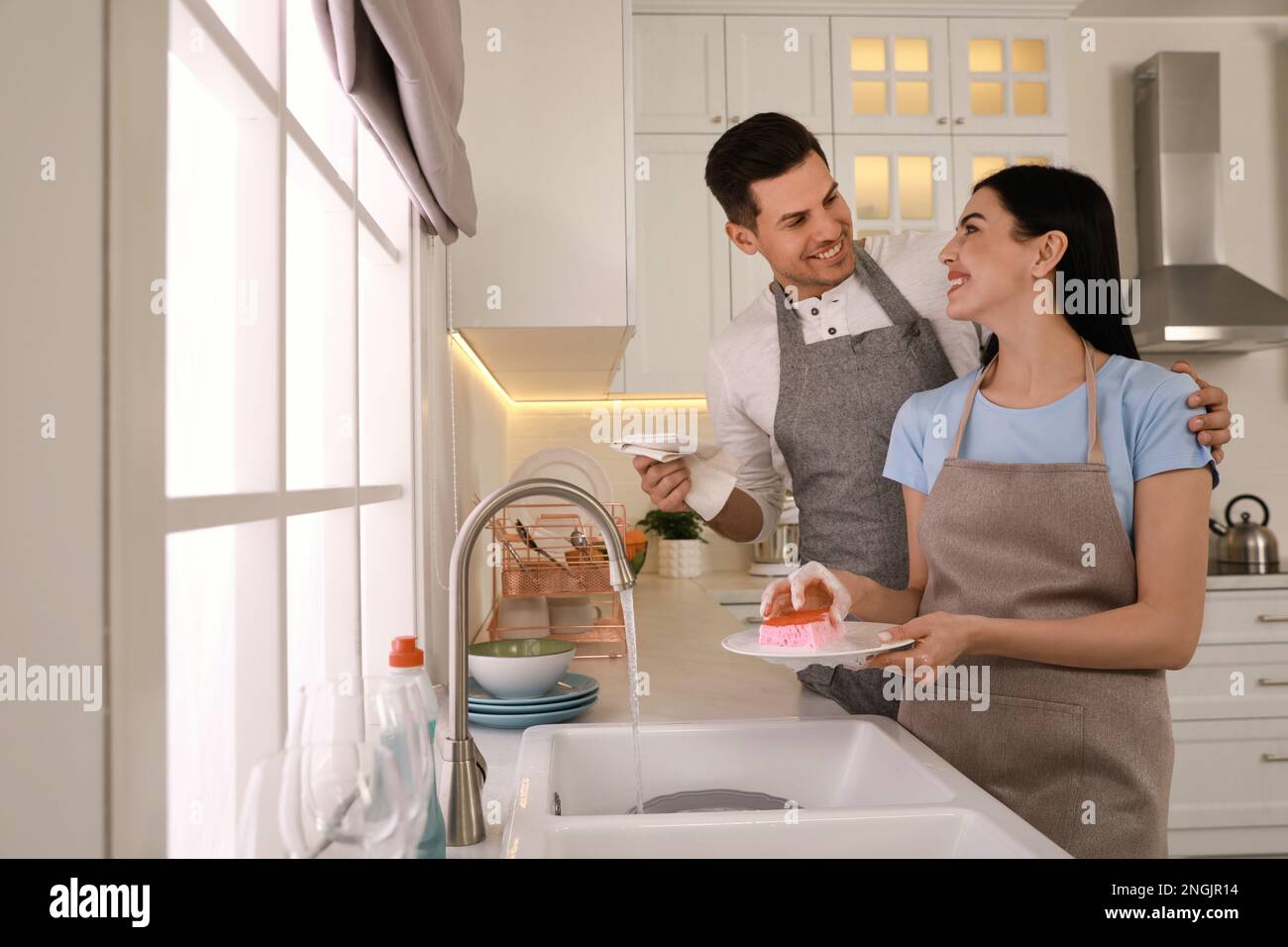 Happy lovely couple washing dishes in kitchen Stock Photo - Alamy