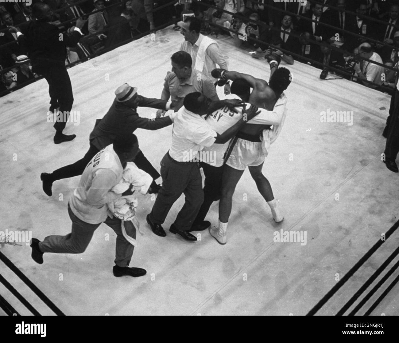 Handlers of Cassius Clay swarm over him in the ring after referee ...